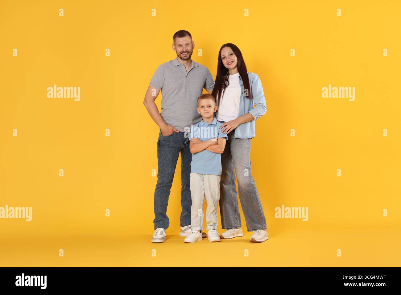 Lovely family posing together on yellow background Stock Photo - Alamy