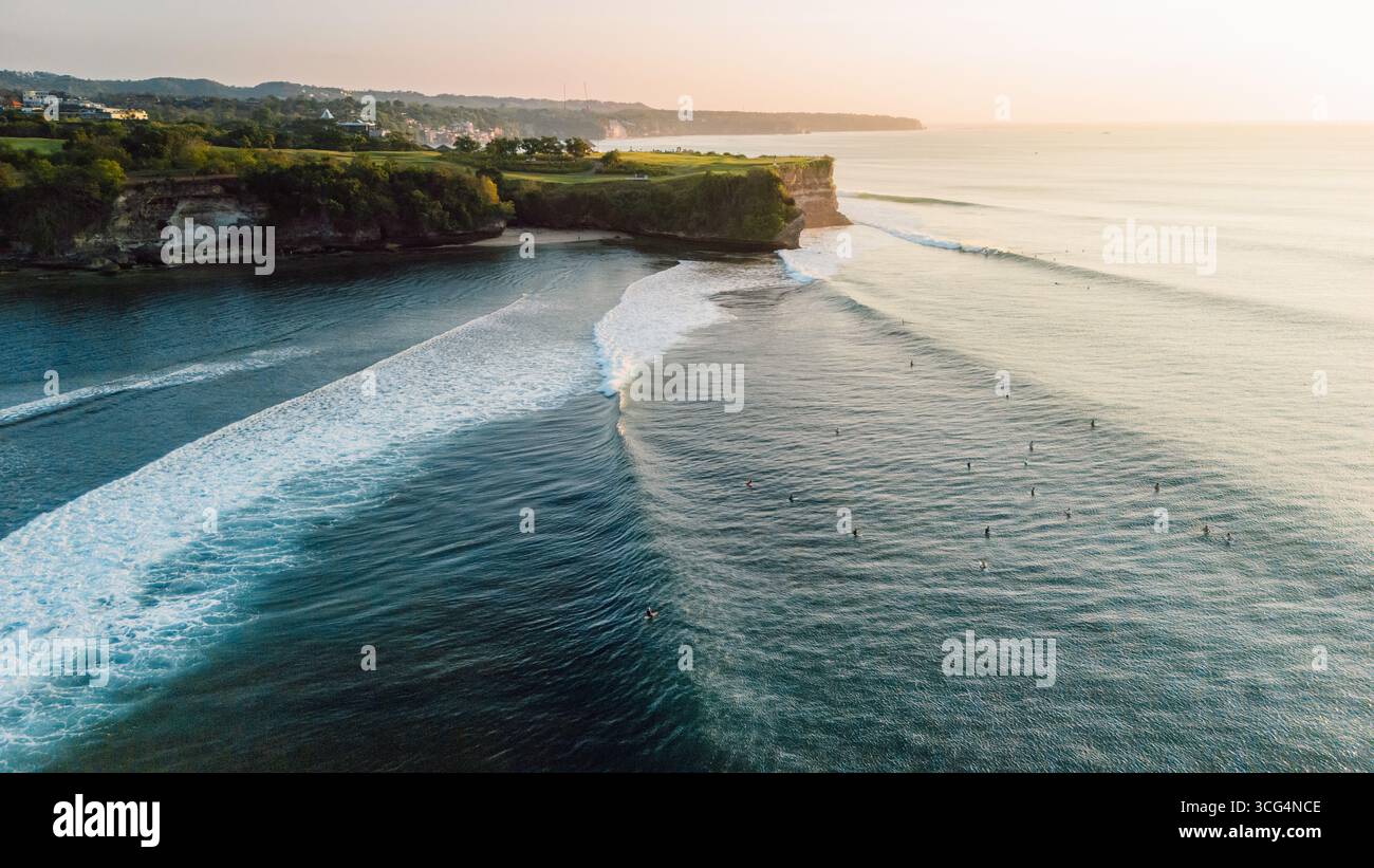 Scenic drone landscape with soft sunset tones and ocean with surfing ...