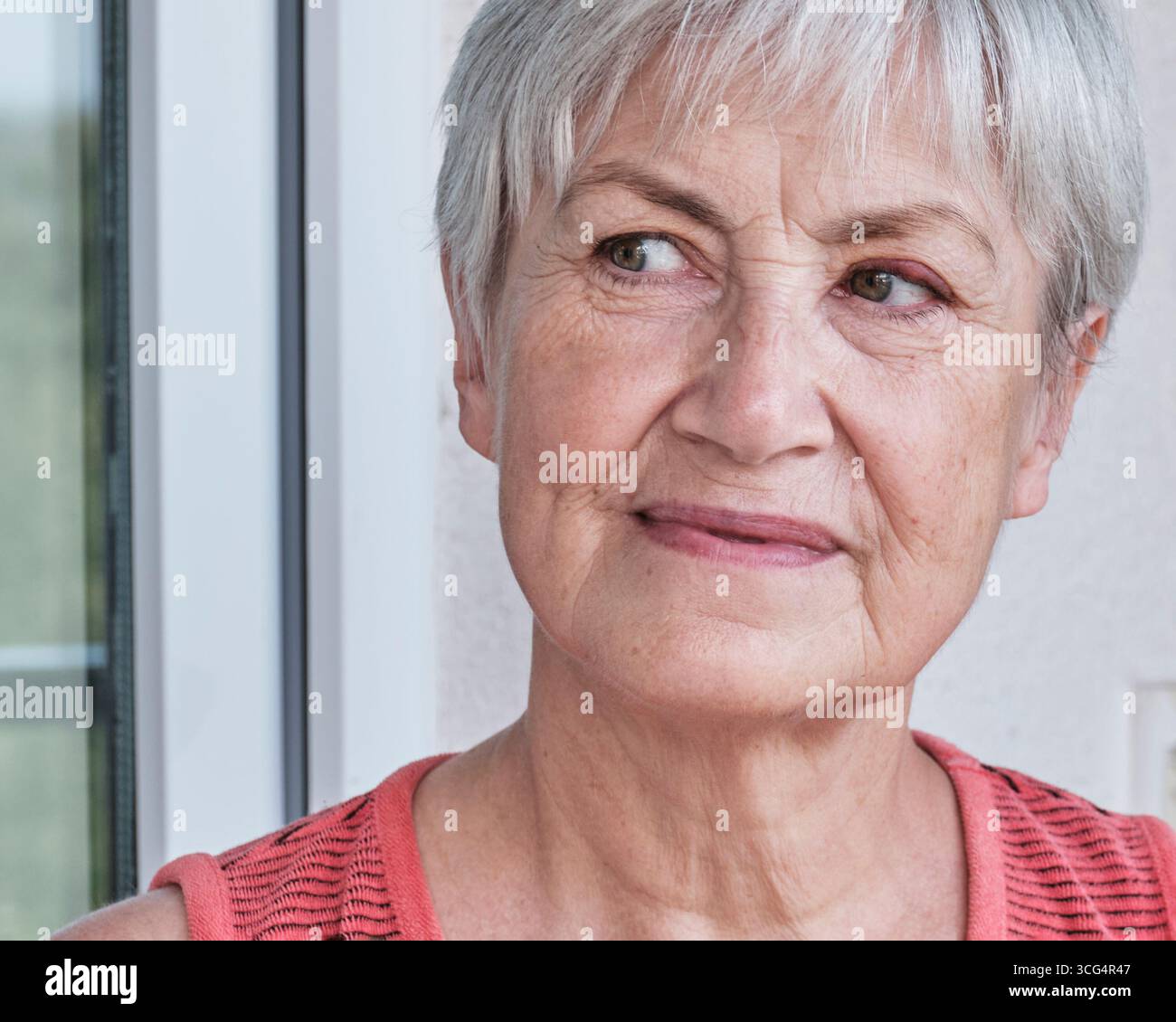 Close-up portrait of a senior woman with short grey hair, showing a ...