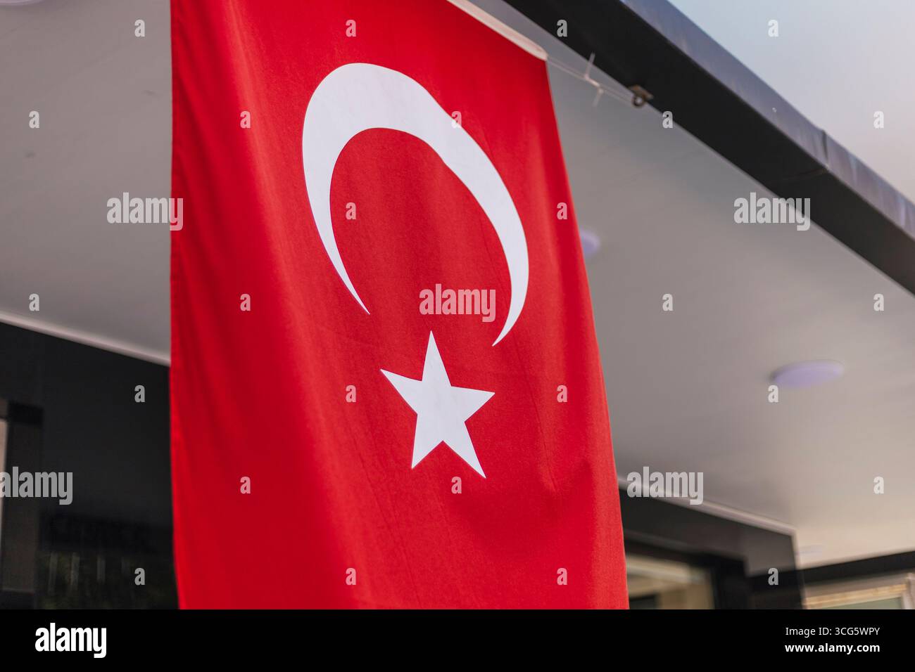 A vibrant red Turkish flag with a white star and crescent is hanging ...