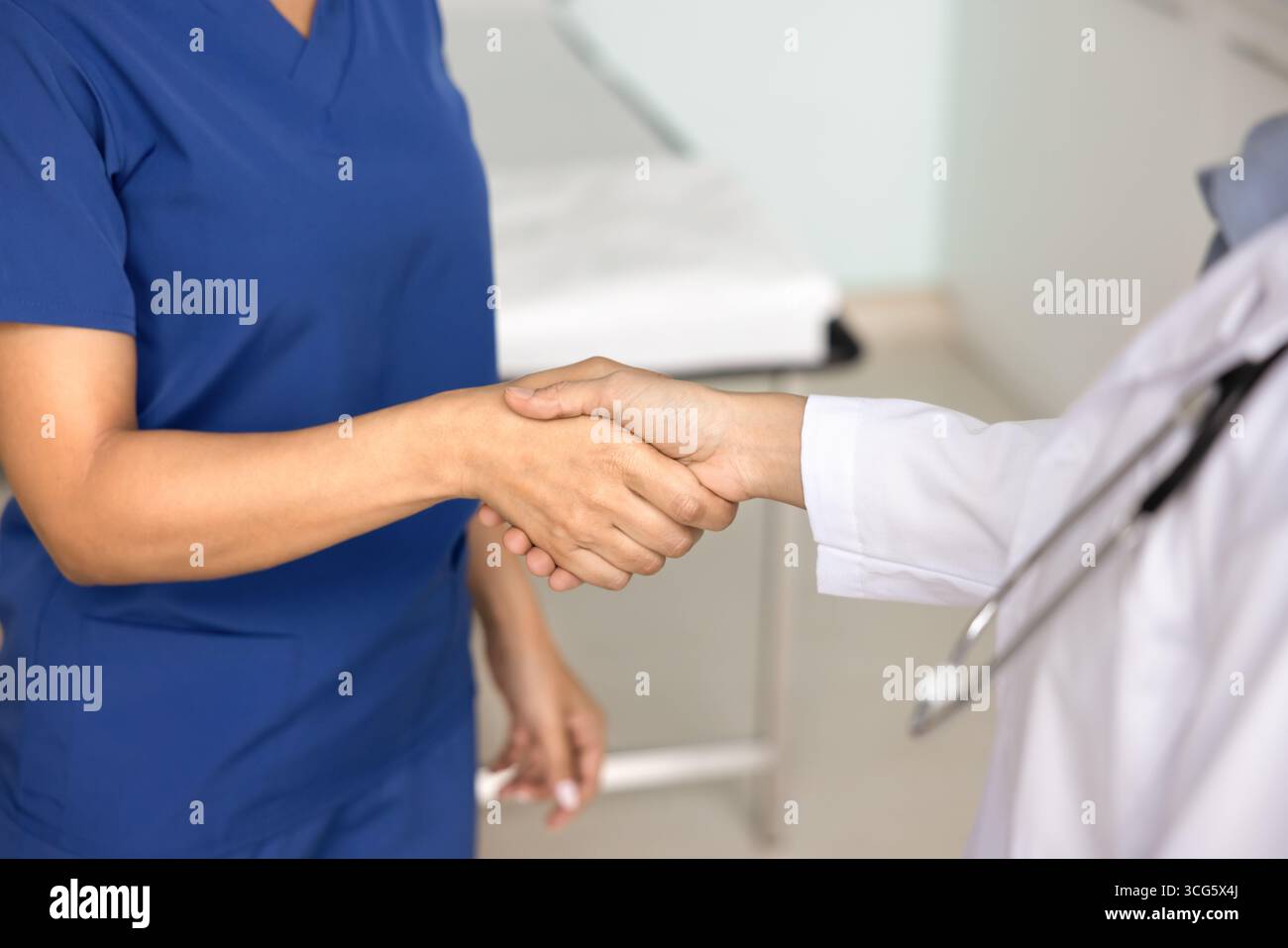 Two female doctors giving handshake close up Stock Photo - Alamy