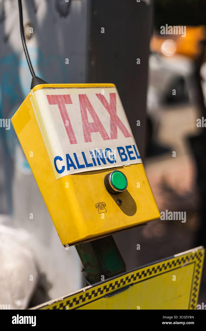 A bright yellow calling bell marked 'TAX' and 'CALLING BELL' hangs in a ...