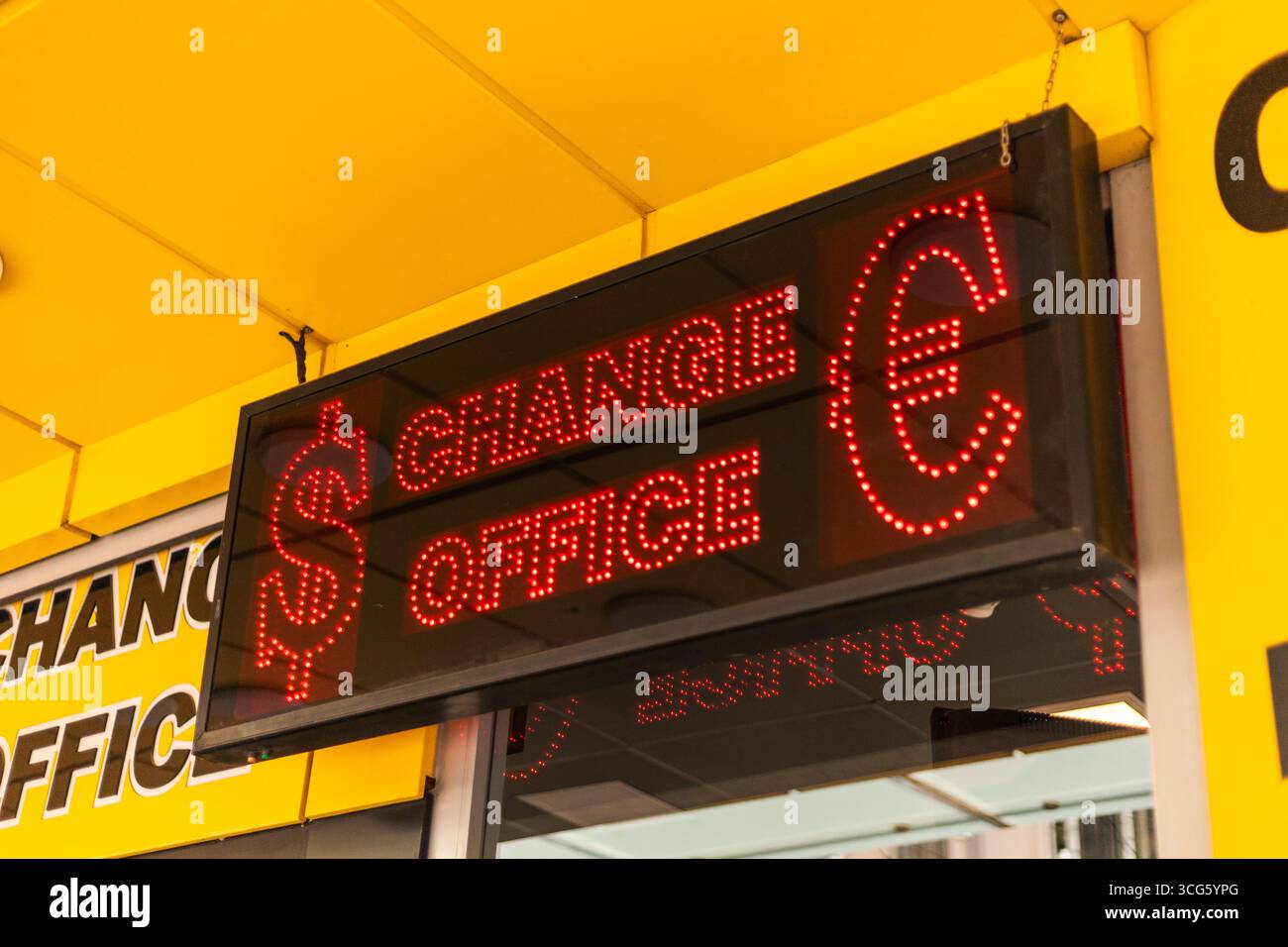 A vibrant neon illuminated sign indicates a currency exchange office ...