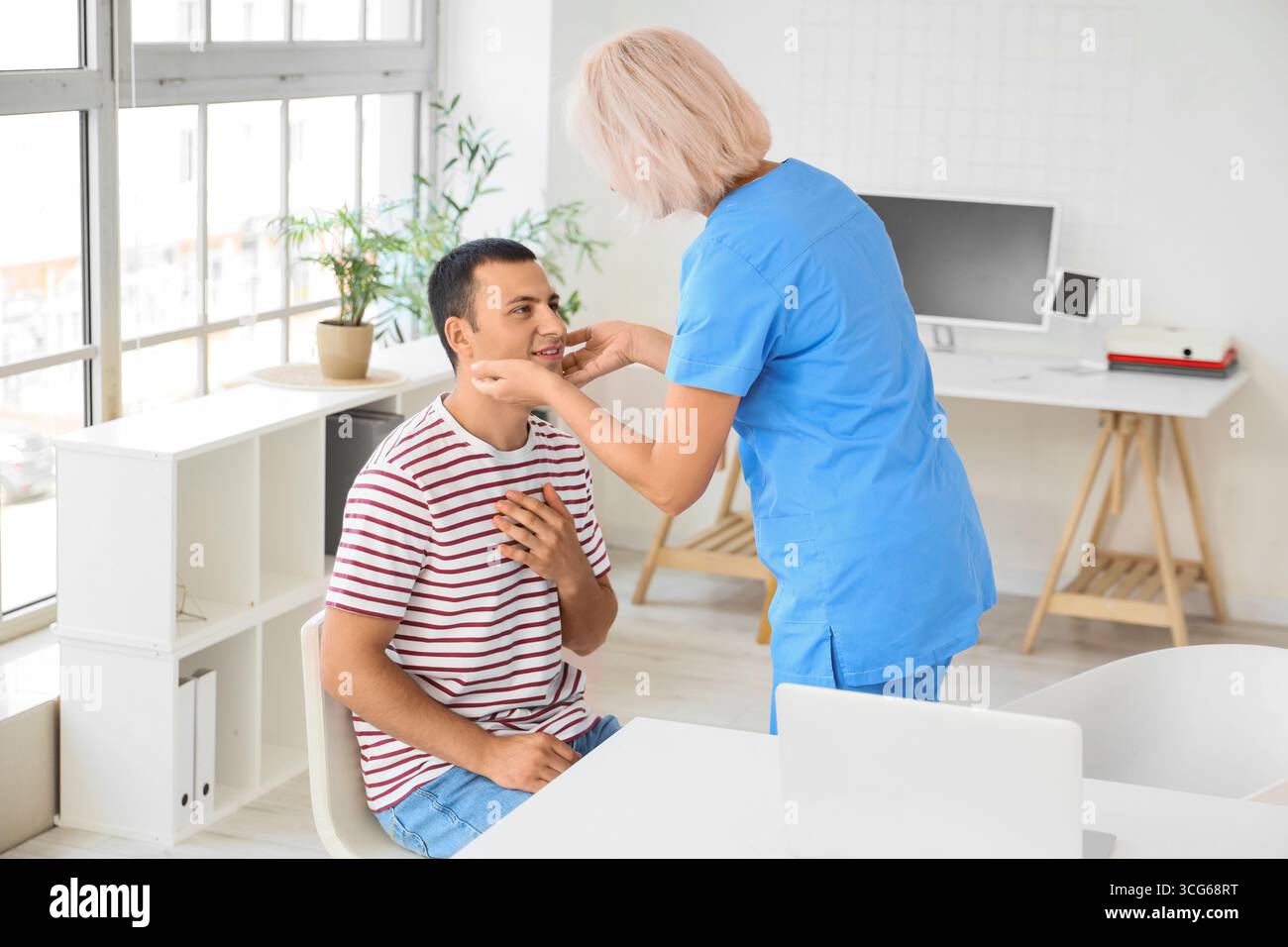 Female endocrinologist examining young man in clinic Stock Photo - Alamy