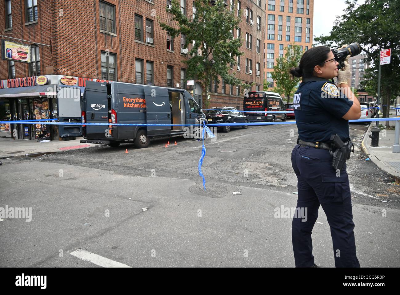 An NYPD officer seen recording at the scene with a camera, where a 31 ...
