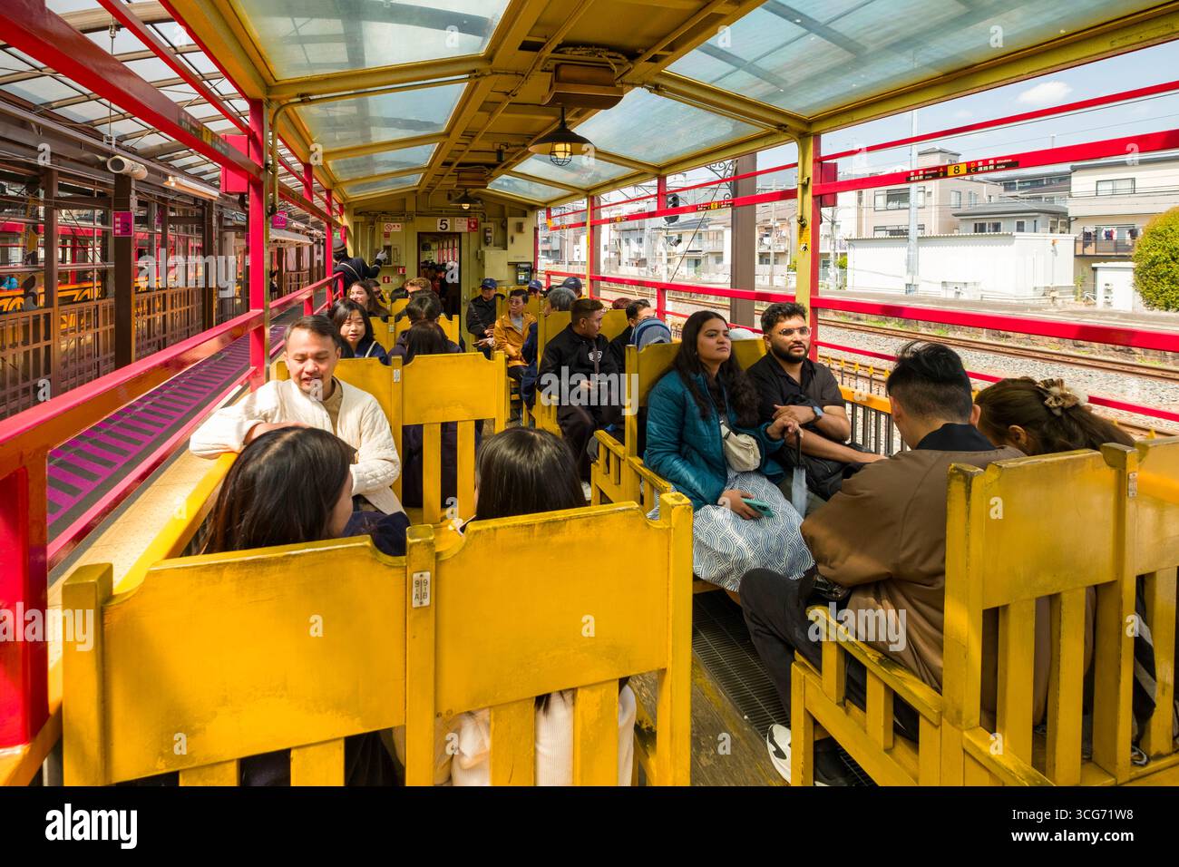 Passengers sitting on wooden seats in the Sagano romantic train as it ...