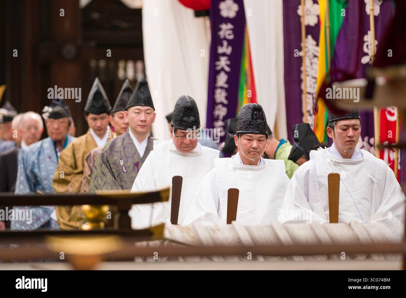Procession of Shinto priests wearing traditional robes and hats during ...