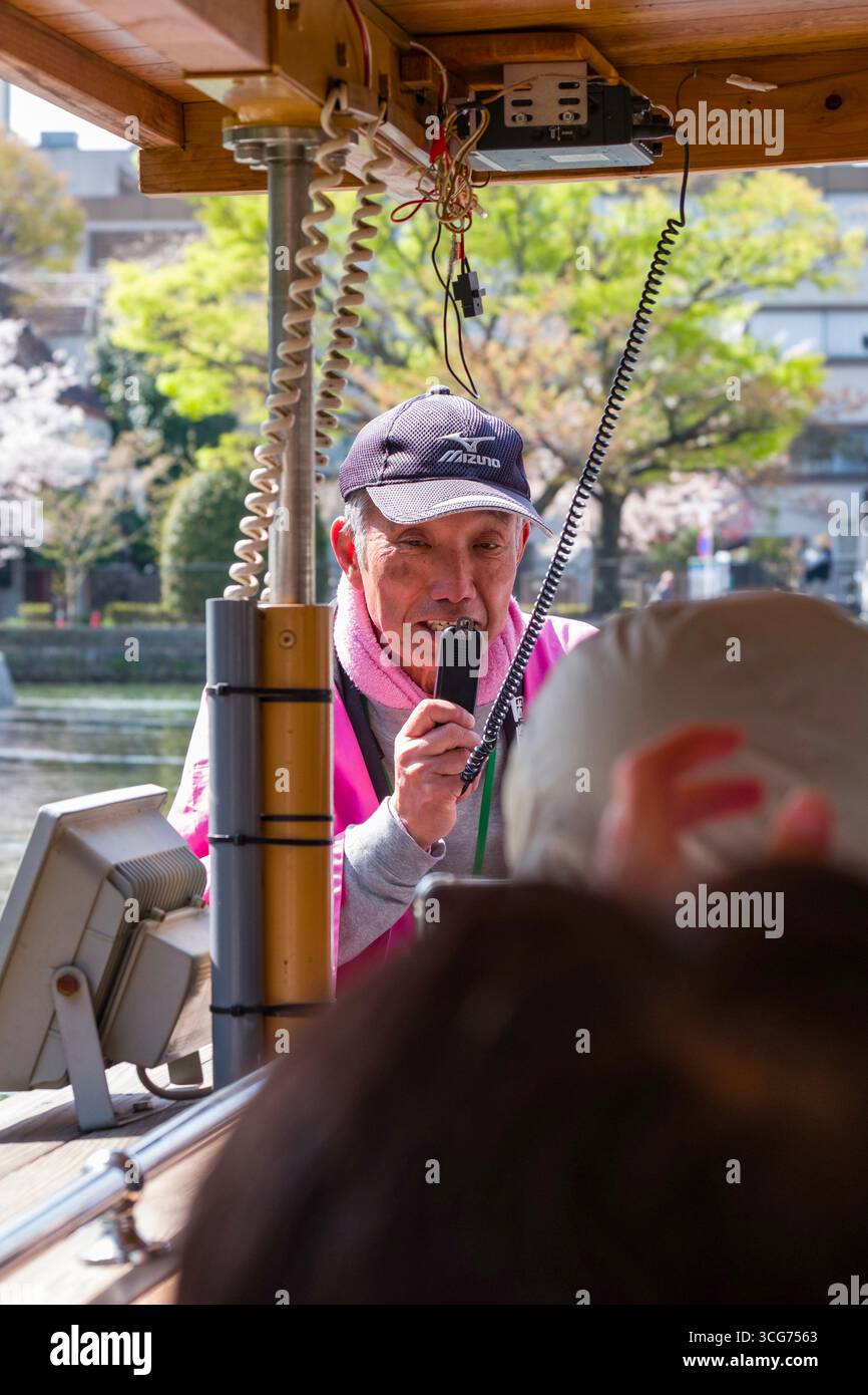 Japanese male tour guide speaking into microphone during an Okazaki ...