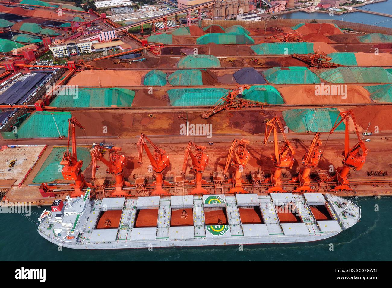 QINGDAO, CHINA - AUGUST 27, 2025 - A cargo ship unloads imported iron ...