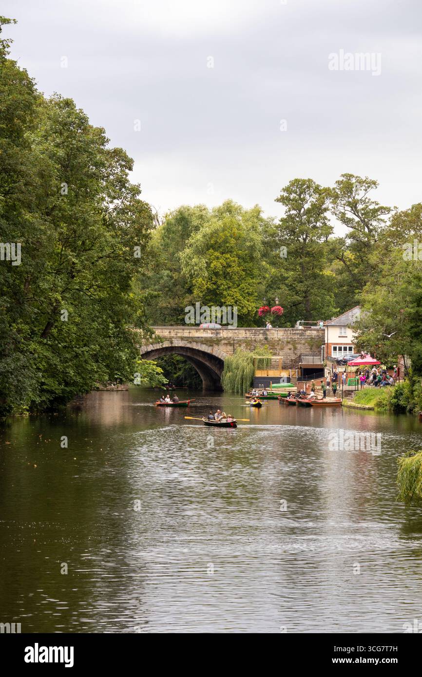 Scenic view of a stone arch bridge crossing a calm river, with small ...