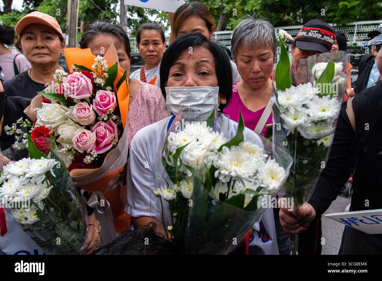 Anchan Preelert (C) receives flowers from her supporters after her ...