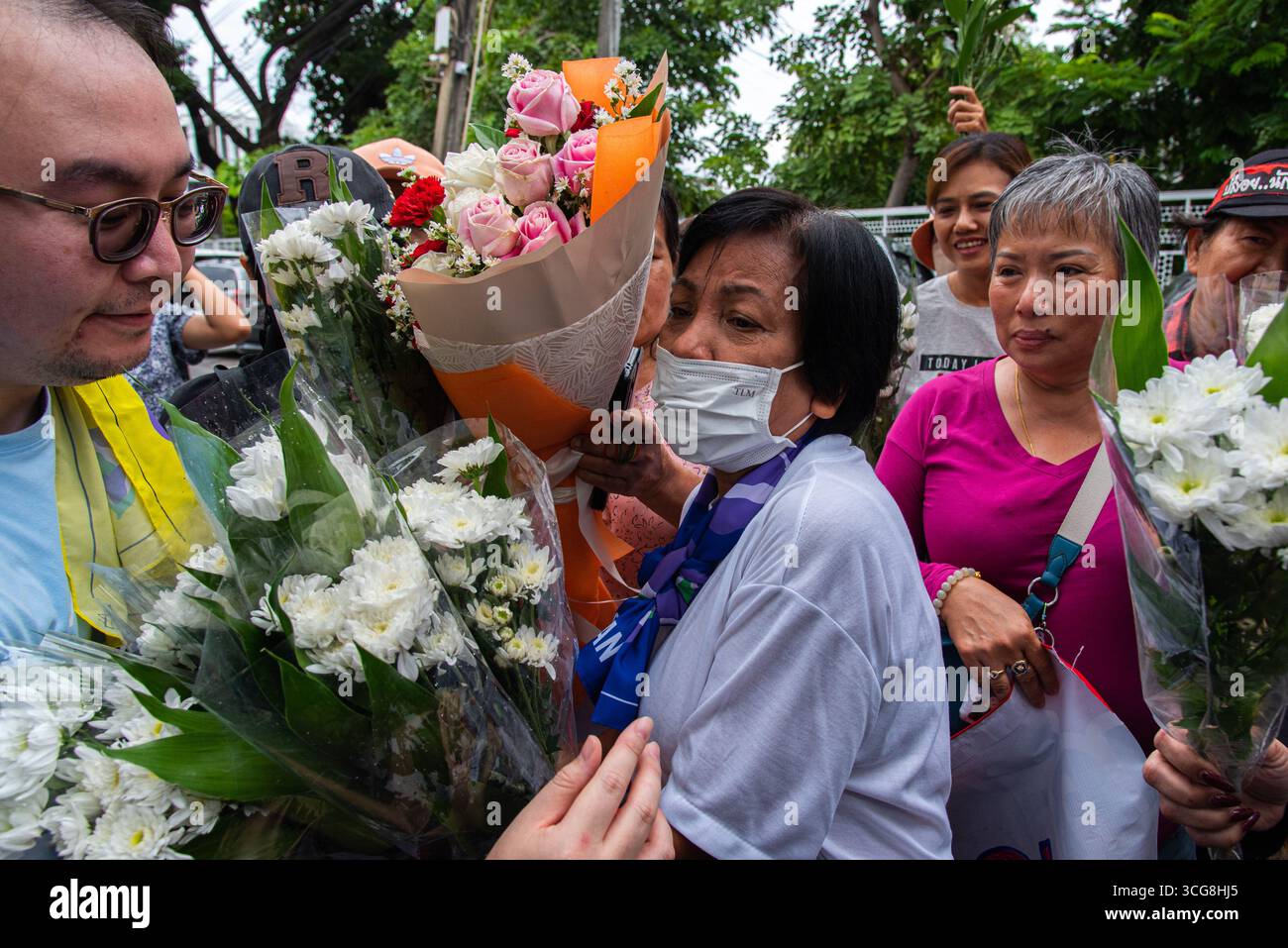 Anchan Preelert (C) receives flowers from her supporters after her ...
