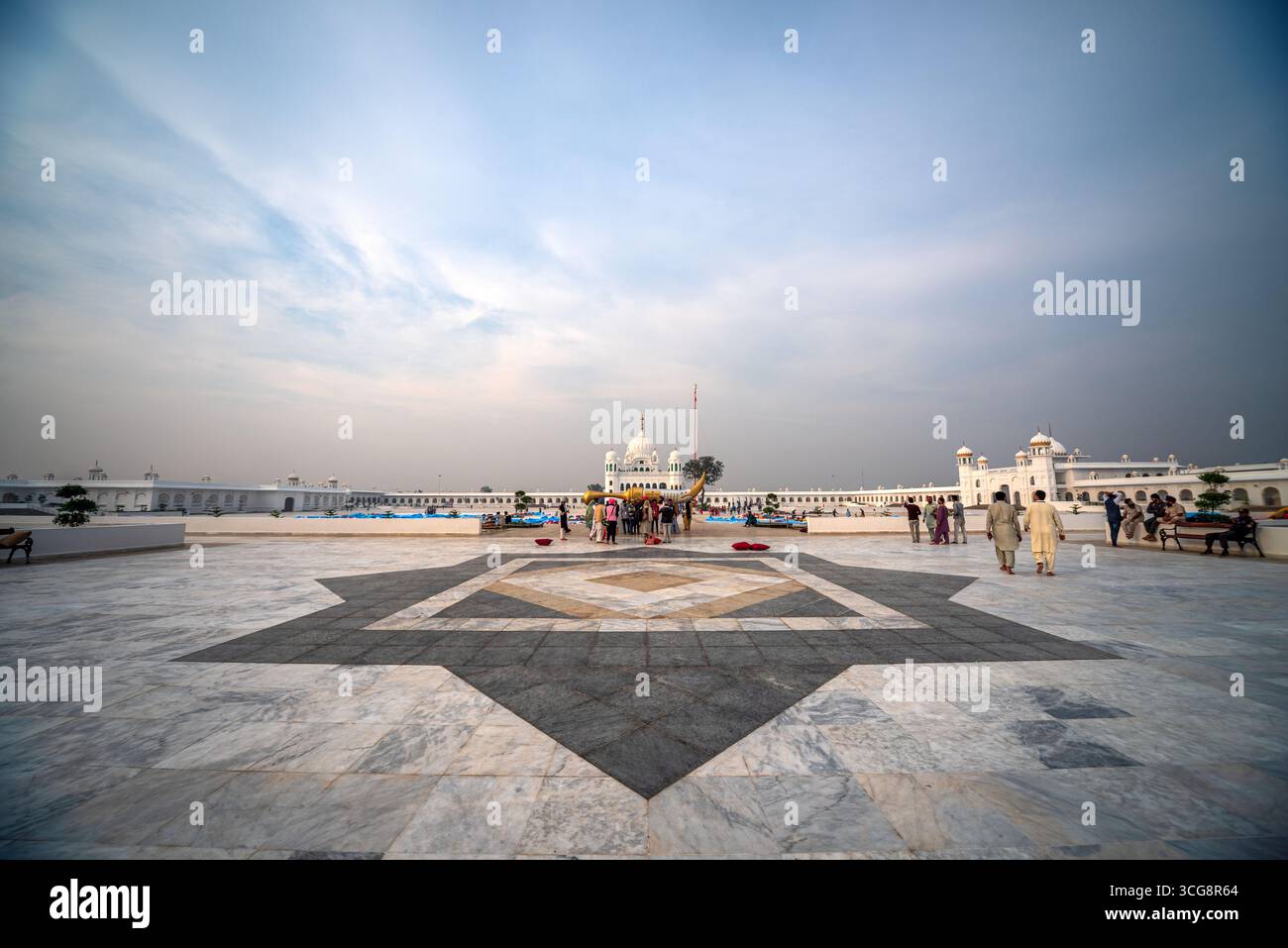 View of pilgrims strolling on the marble terrace with geometric ...