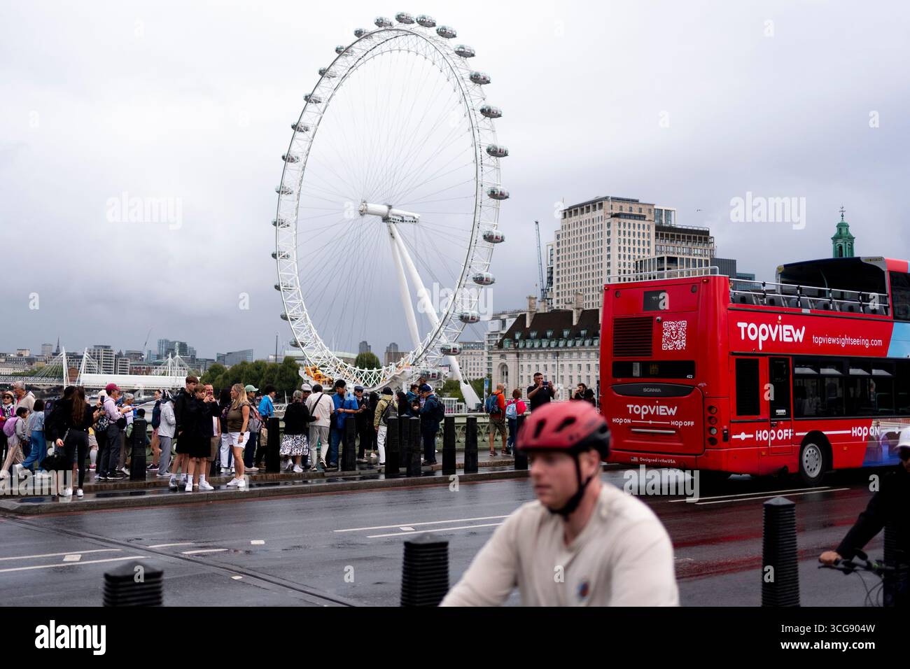Pedestrians walk in front of the London Eye in Westminster, London ...