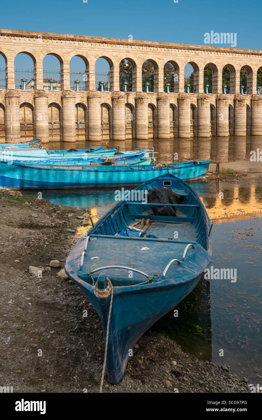 Historic Beysehir Stone Bridge with blue boats on lake Stock Photo - Alamy
