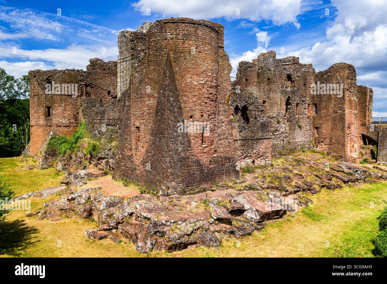 Crumbling stone walls and towers of an ancient castle under a blue sky ...
