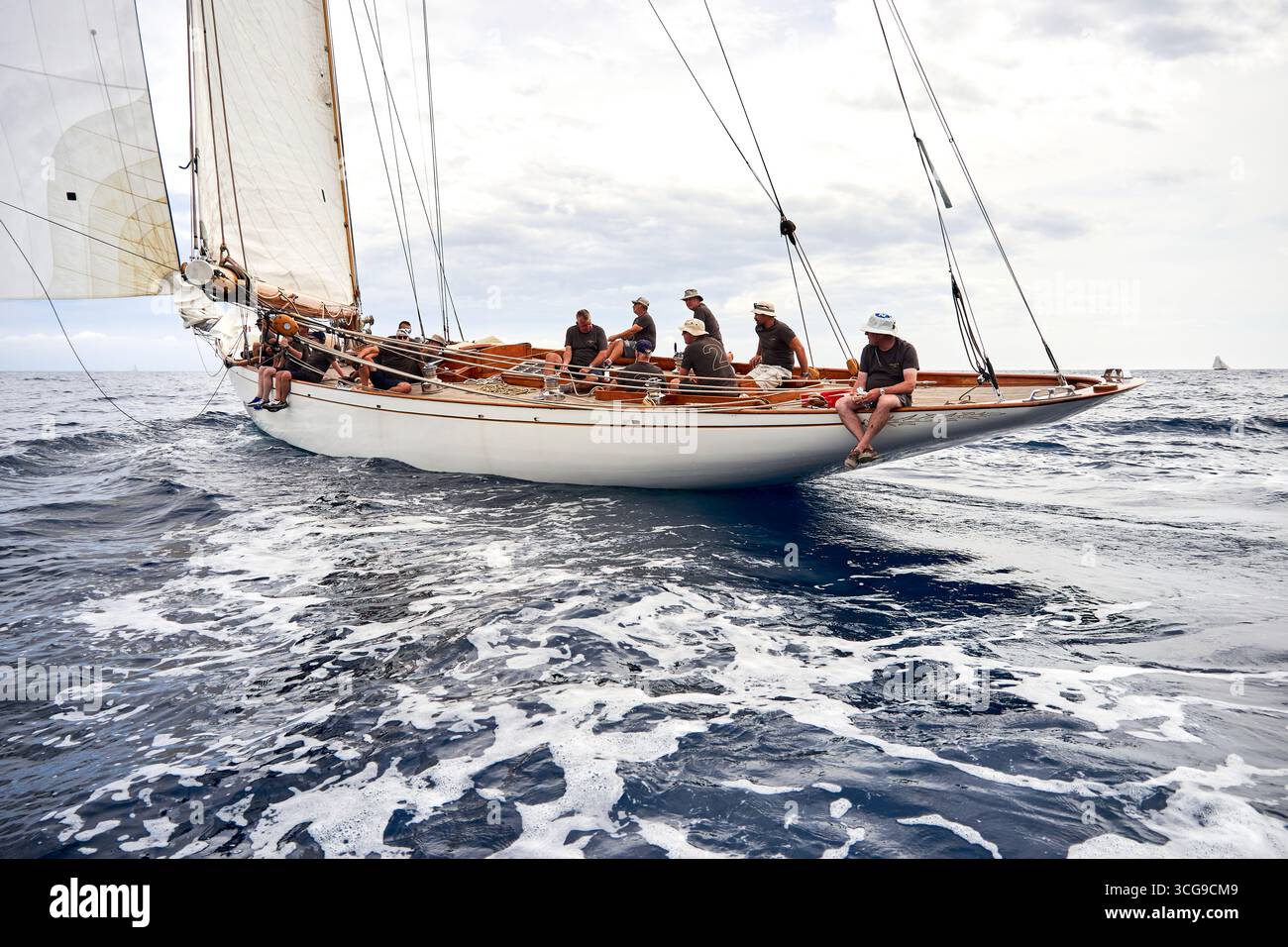 Sailboat with Crew Navigating the Open Sea During a Breezy Day Stock ...
