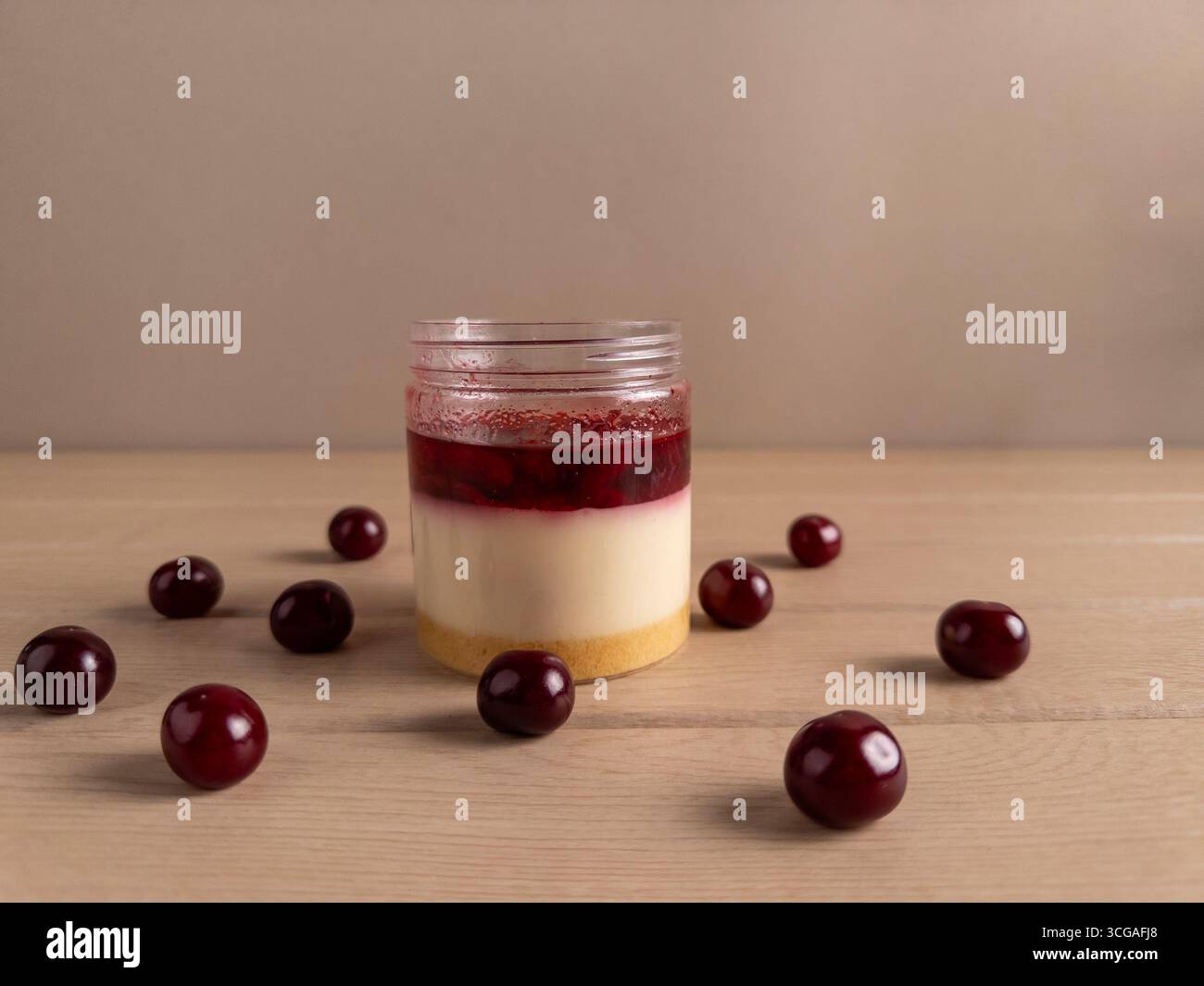A luscious cherry cheesecake in a jar featuring layered creamy filling ...