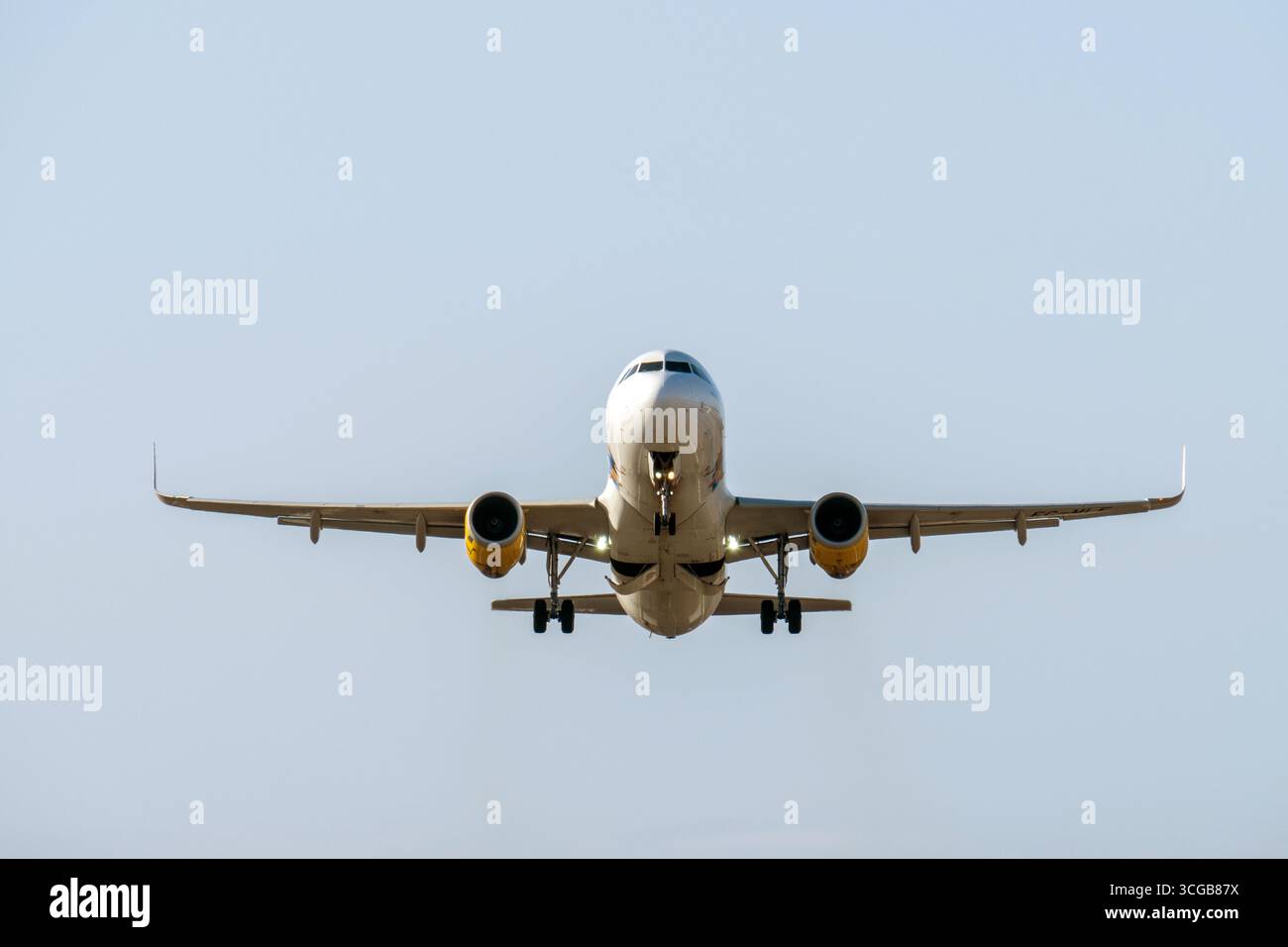 Modern passenger airplane approaching runway with landing gear down and ...