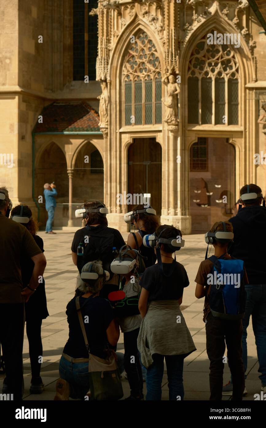 A group of people wearing VR glasses stands with their backs to the ...