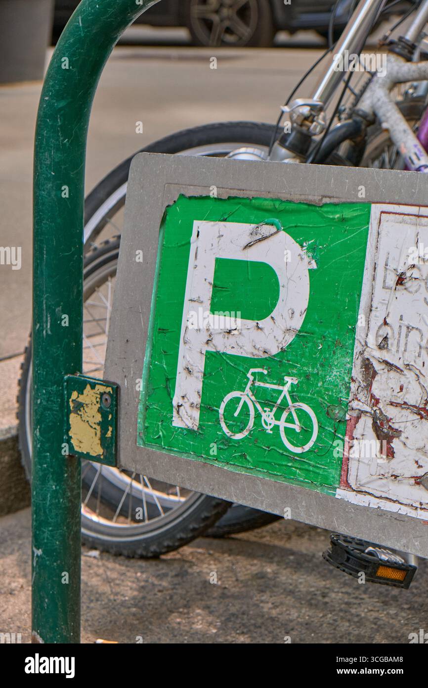 Detailed close-up of an old green bicycle parking sign with peeling ...