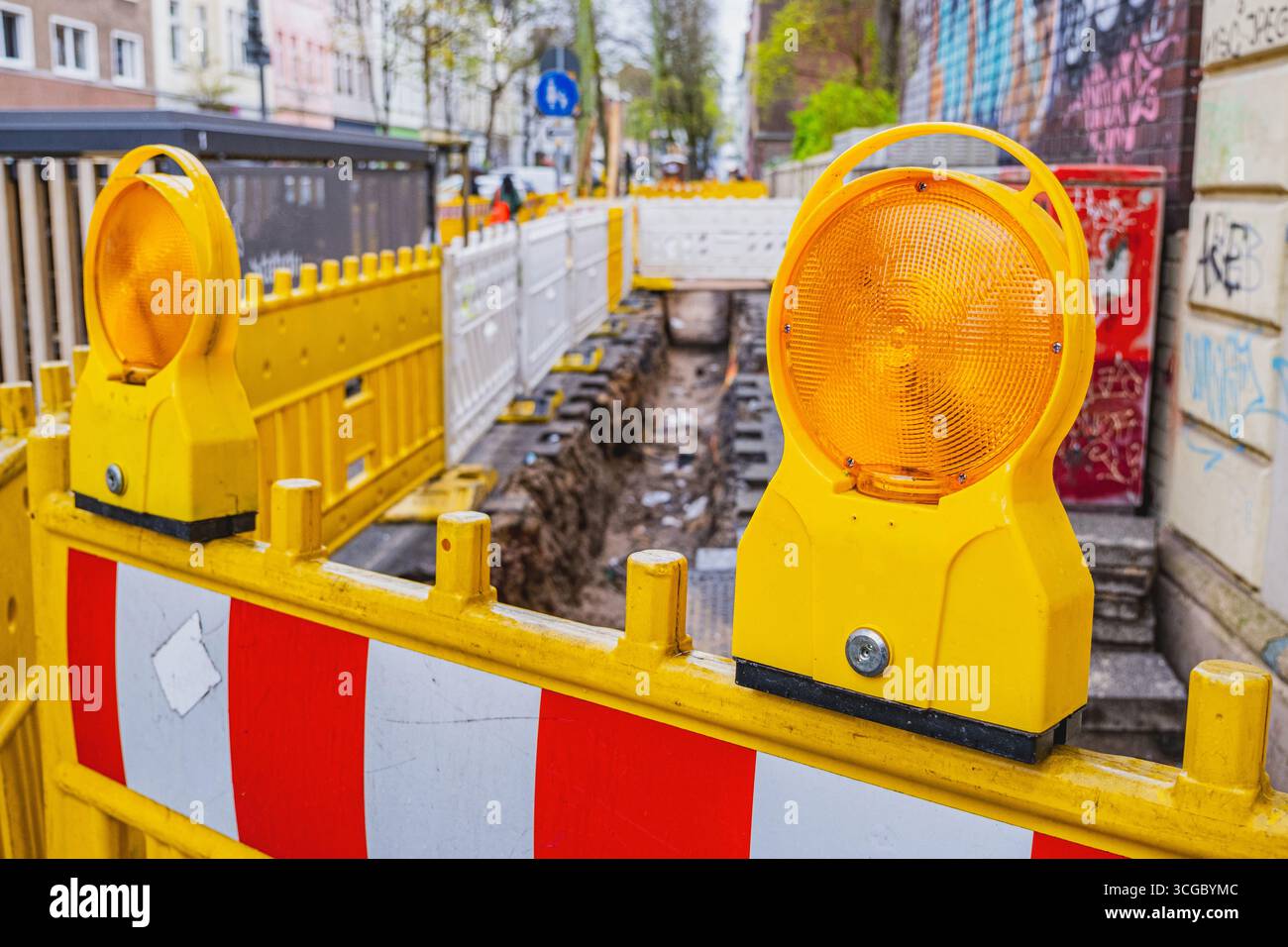 Bright orange construction barriers with lights on Flurstrasse during ...
