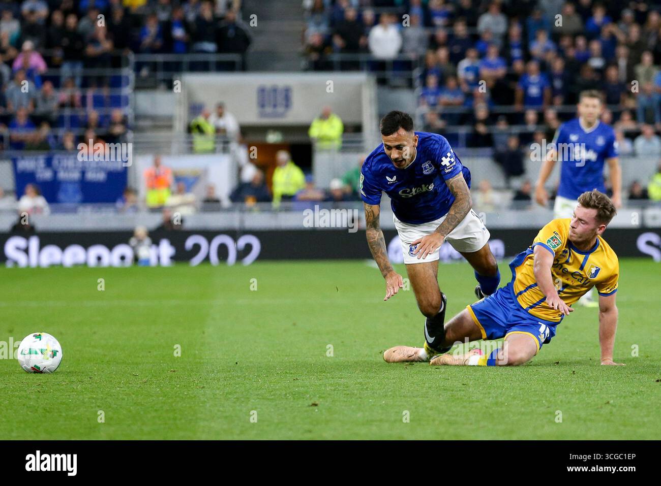 Jamie McDonnell of Mansfield Town (r) tackles Dwight McNeil of Everton ...