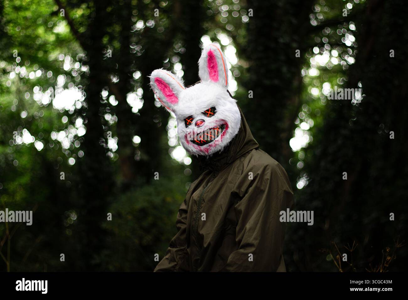 Creepy white bunny Halloween mask glowing with red LED lights in a dark ...