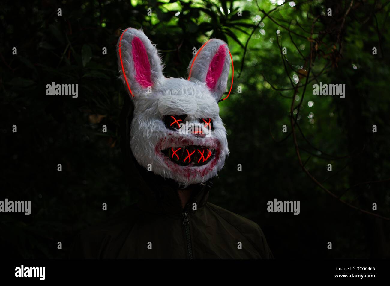 Creepy white bunny Halloween mask glowing with red LED lights in a dark ...