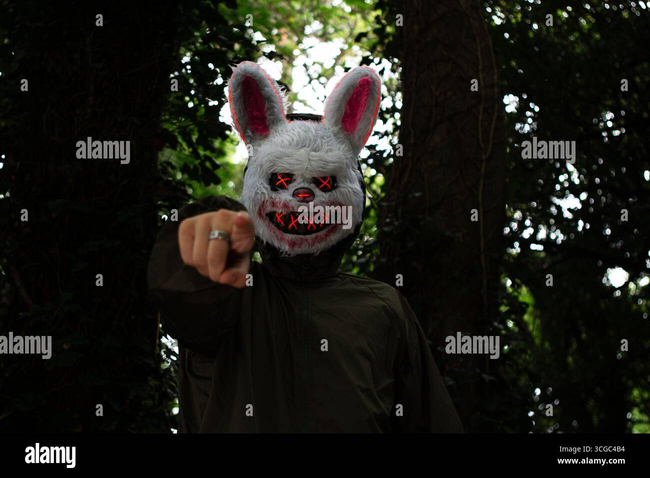 Creepy white LED bunny mask with glowing red lights pointing finger ...