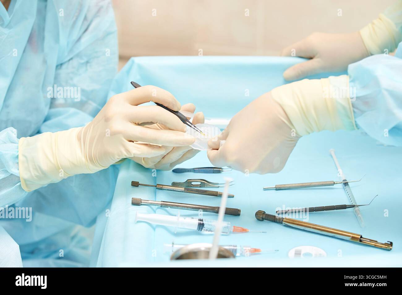Surgeons preparing tools for surgery in an operating room setting with ...