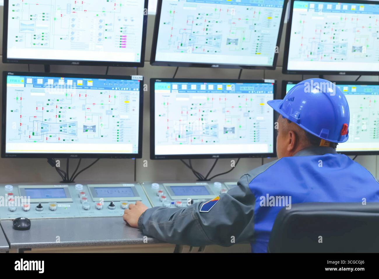 the operator of the equipment control panel at the LNG plant sits ...