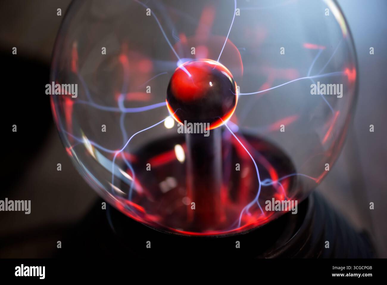 A view of the glowing electricity emitted from a plasma ball lamp, as a ...