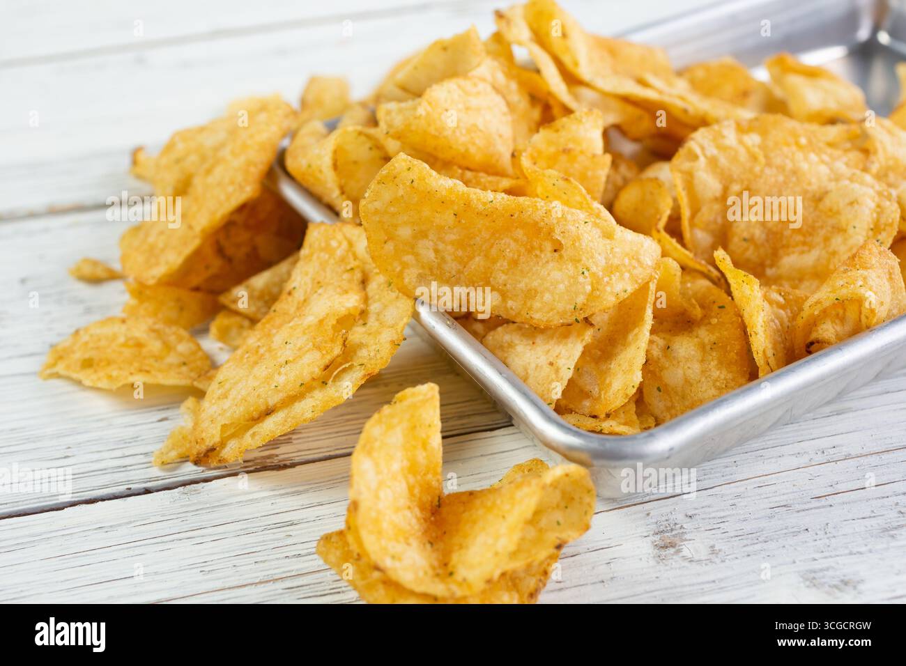 A closeup view of a metal tray full of seasoned potato chips Stock ...
