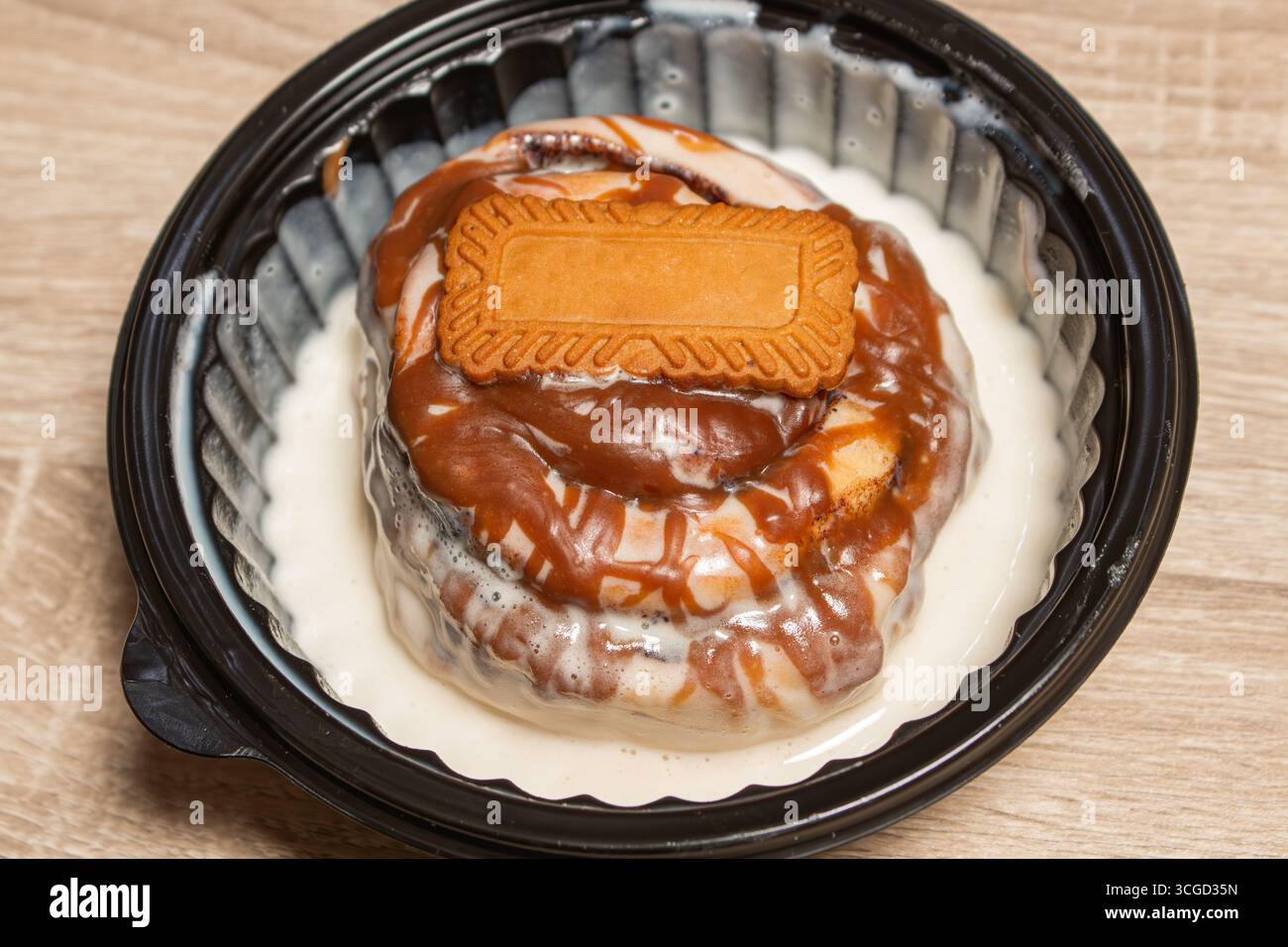 A decadent fresh cinnamon swirl bun drenched in creamy white icing and ...