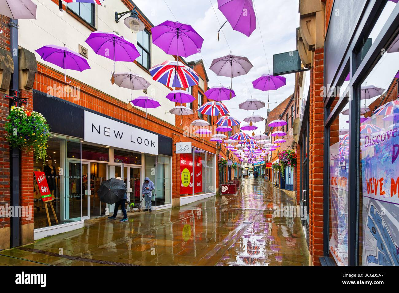 A colorful umbrella sky display above a shopping street on an overcast ...