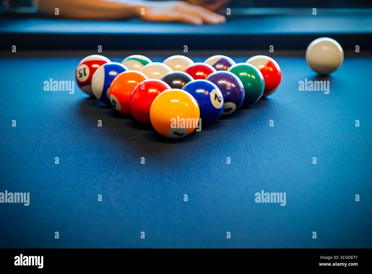 Billiard balls are racked in the starting setup for a game on a blue ...
