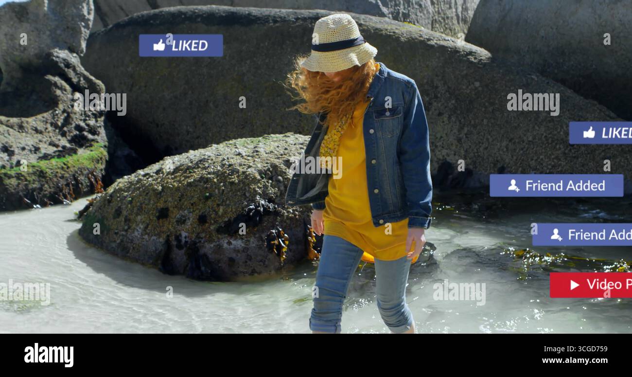 Walking woman navigating rocky tidal pool, with straw sun hat, denim ...