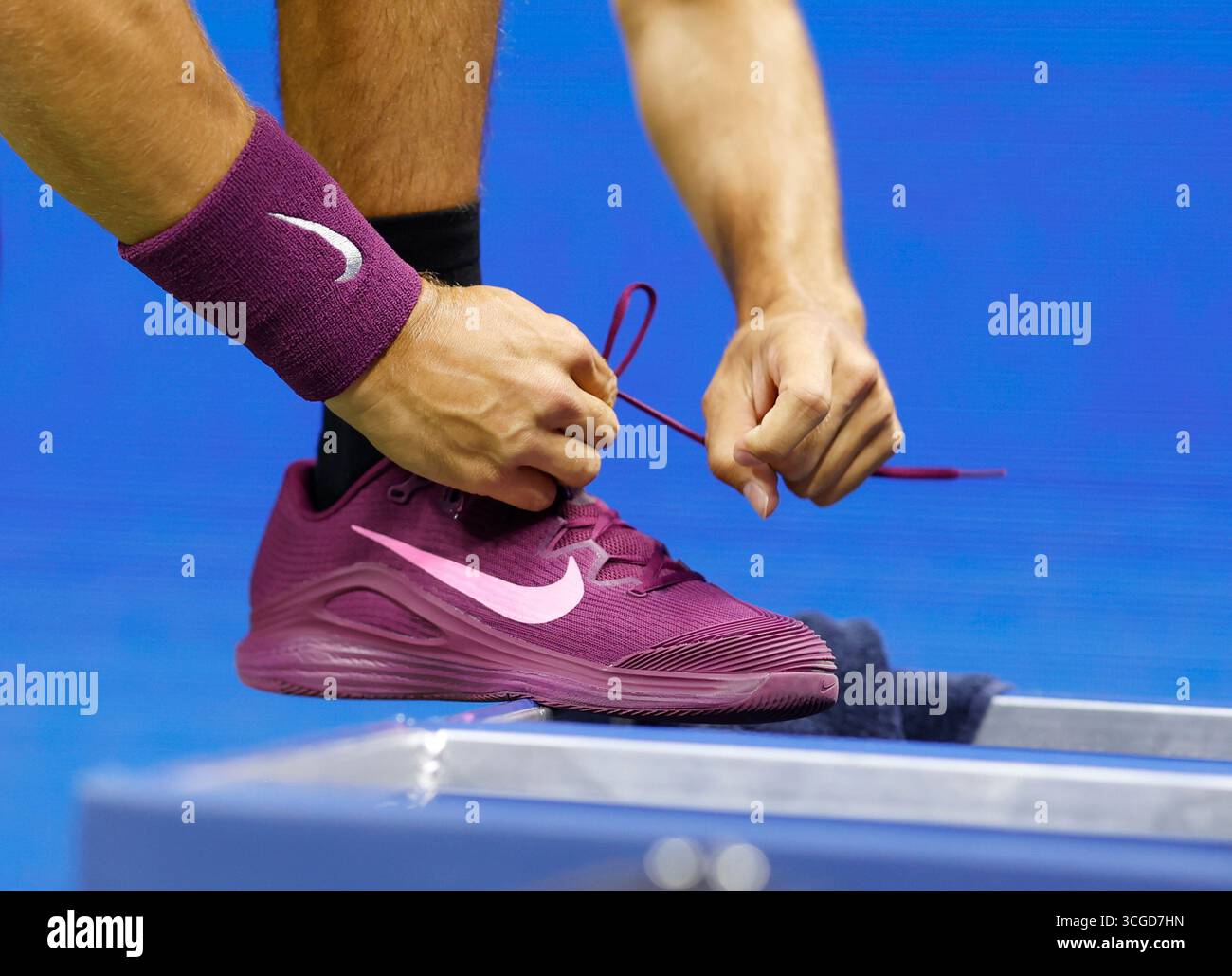 Carlos Alcaraz of Spain ties his sneakers between points in the first ...