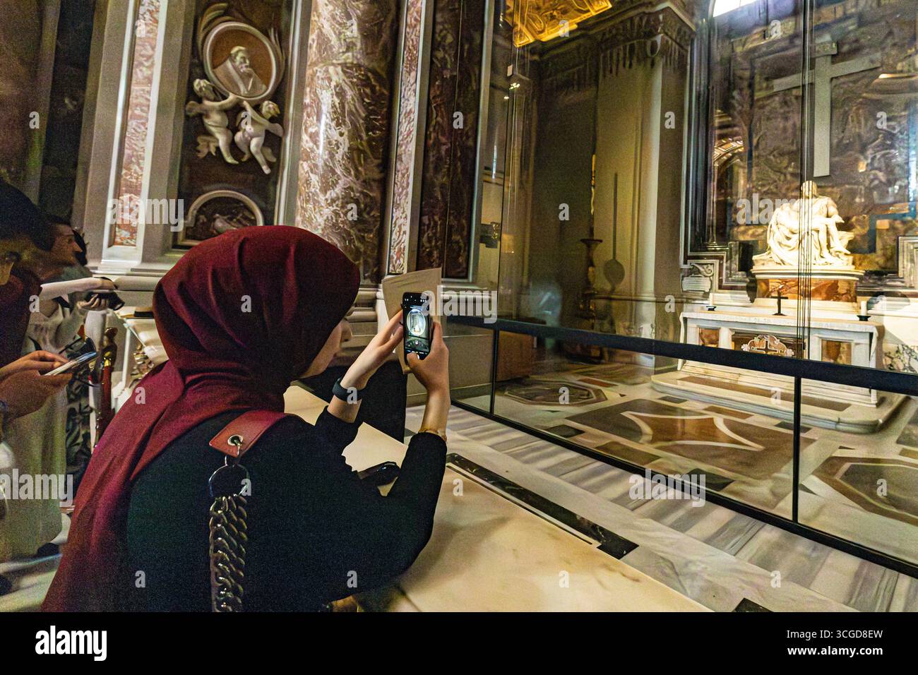 A Muslim woman takes a photograph of Michelangelo's Pieta inside St ...