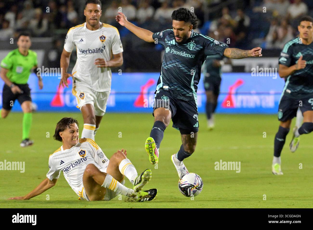 Los Angeles Galaxy defender Julián Aude, left, slides to kicks the ball ...