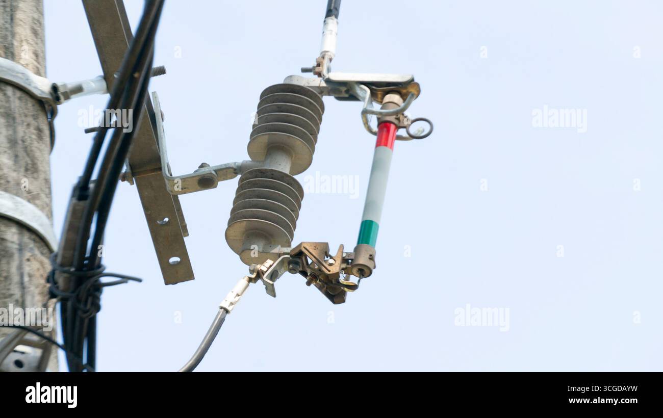 Close-up of an electrical fuse cutout and porcelain insulator on a ...