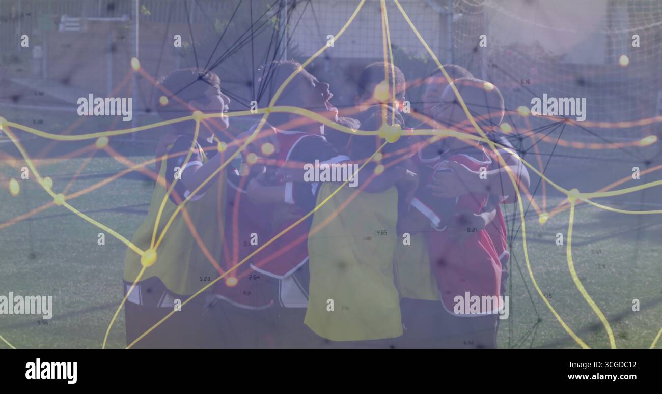 Huddling nine boys wearing colorful training bibs on soccer turf with ...