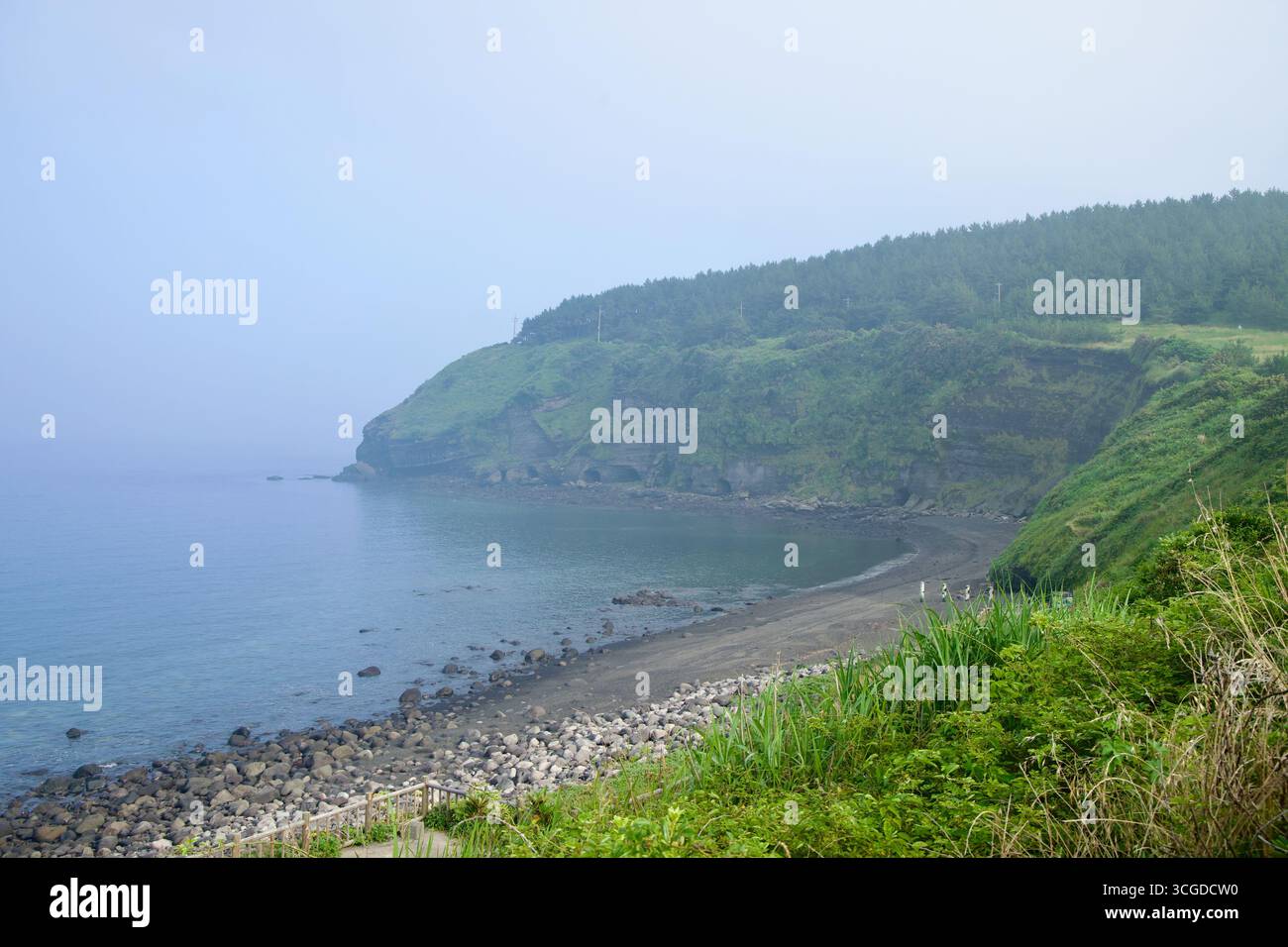 The dark‑sand cove beneath Songaksan curves below green cliffs where ...
