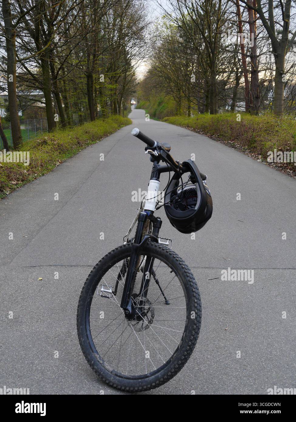 Black and white mountain bike is leaning against a curb on a road Stock ...