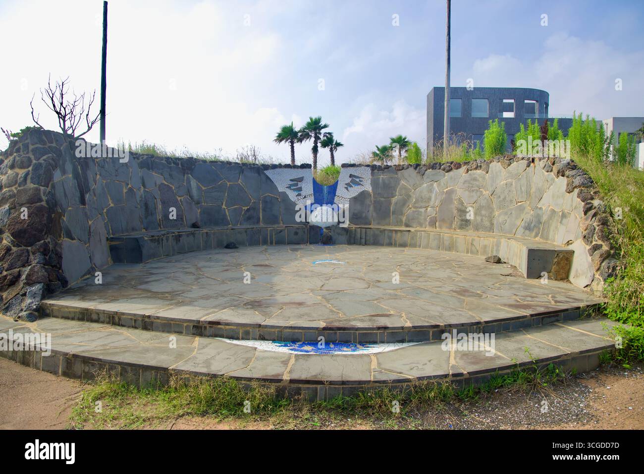 A semicircular stone amphitheater with mosaic artwork faces the sea at ...