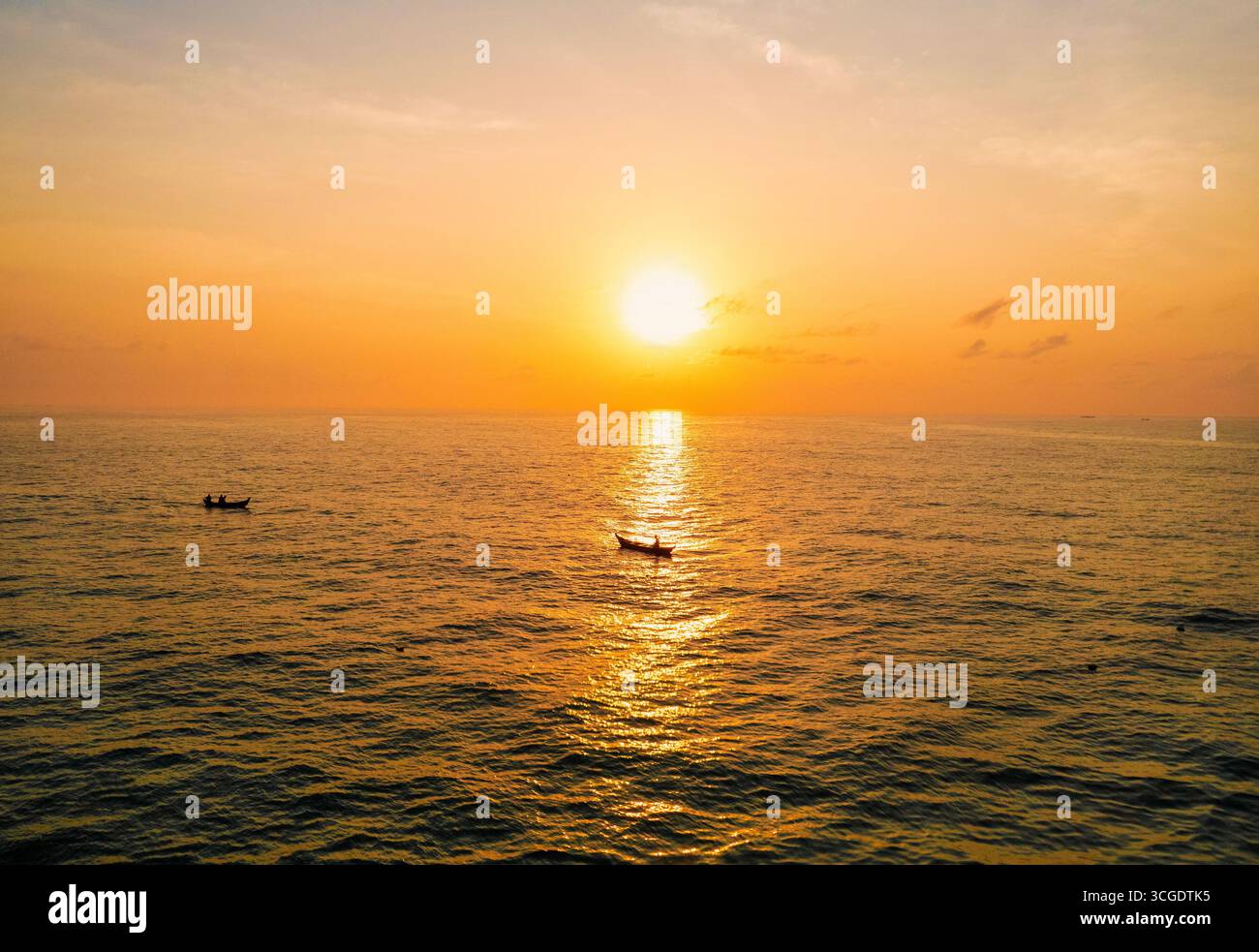 Aerial view of the sun ablaze, casting a golden spell on the tranquil ...