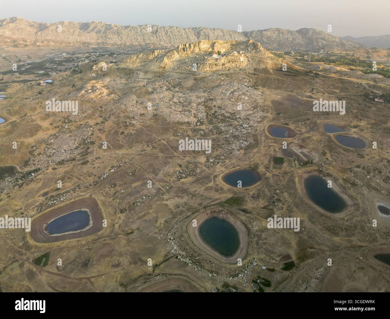 Aerial view of the rough, arid landscape dotted with water reservoirs ...