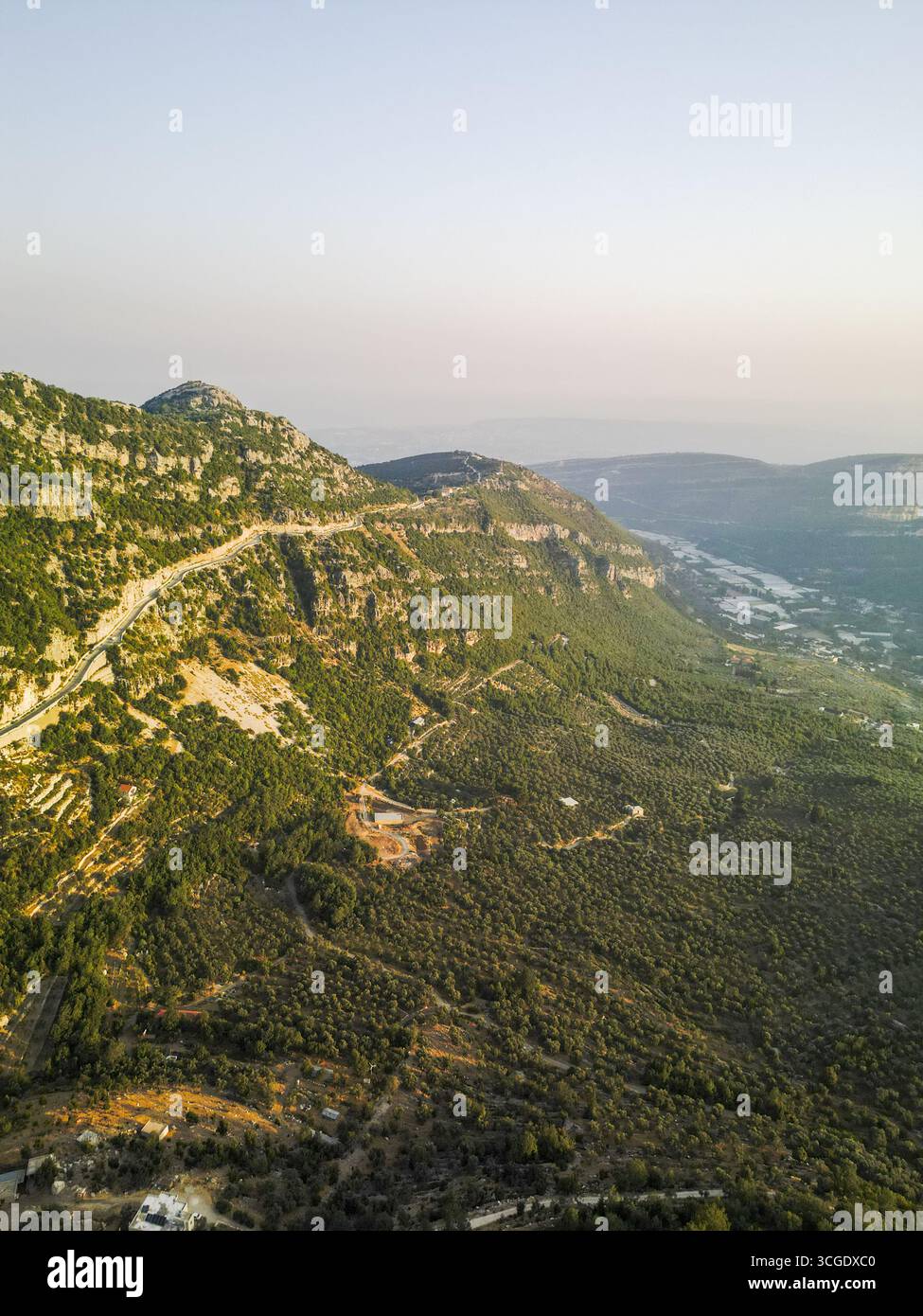 Aerial view of dramatic mountains rise with winding roads carved into ...