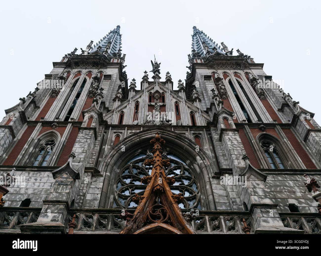 Close-up from below of the spires and facade with a rosette window of ...
